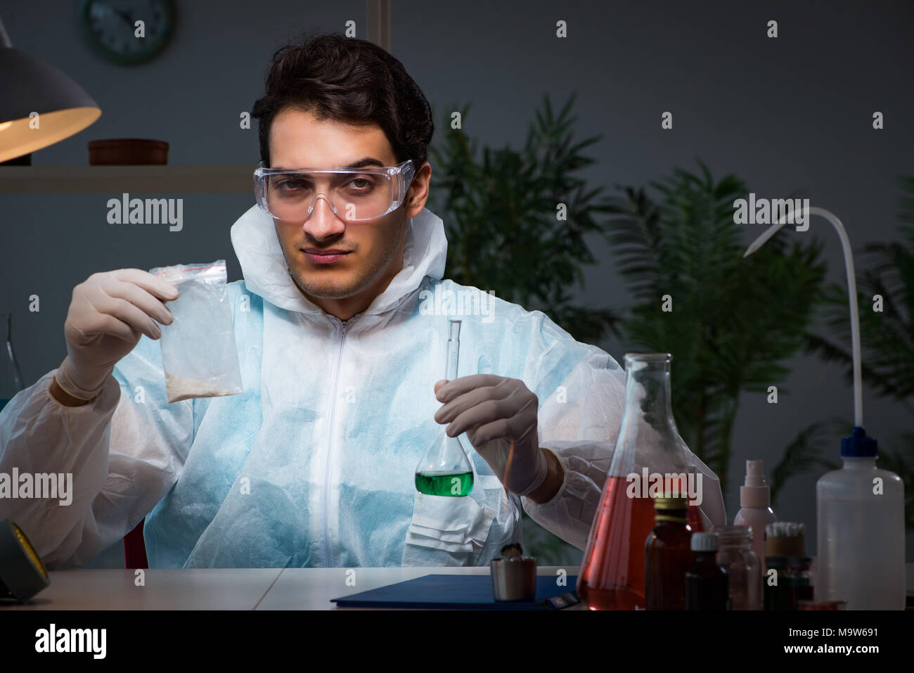 Forensic investigator working in lab looking for evidence Stock Photo ...