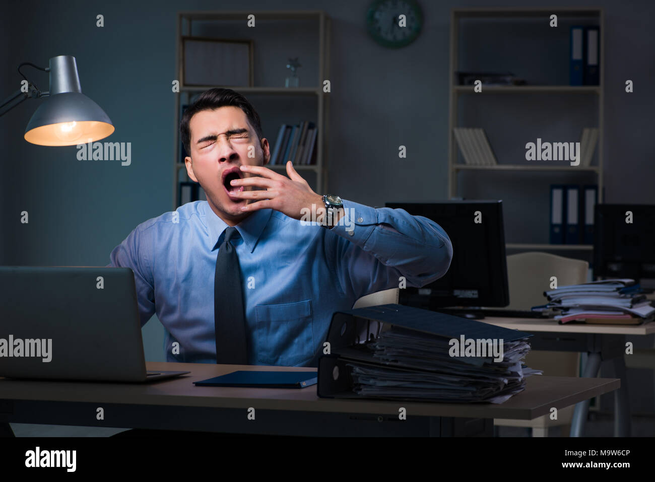 Employee working late at night at important report Stock Photo - Alamy