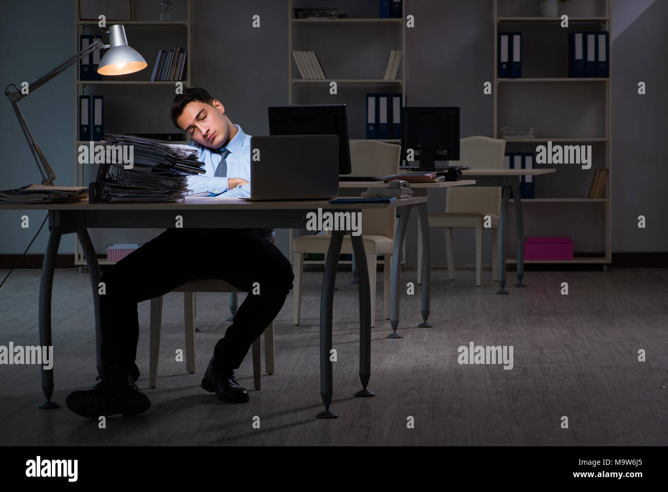 Employee working late at night at important report Stock Photo - Alamy