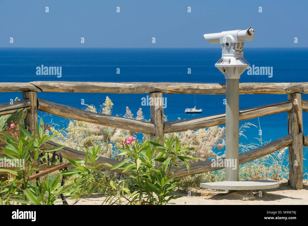 Telescope at the beach with wooden fence Stock Photo - Alamy