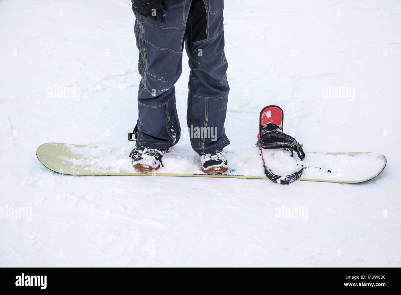 Legs athlete in an snowboard on snow on a sunny day. The concept of ...