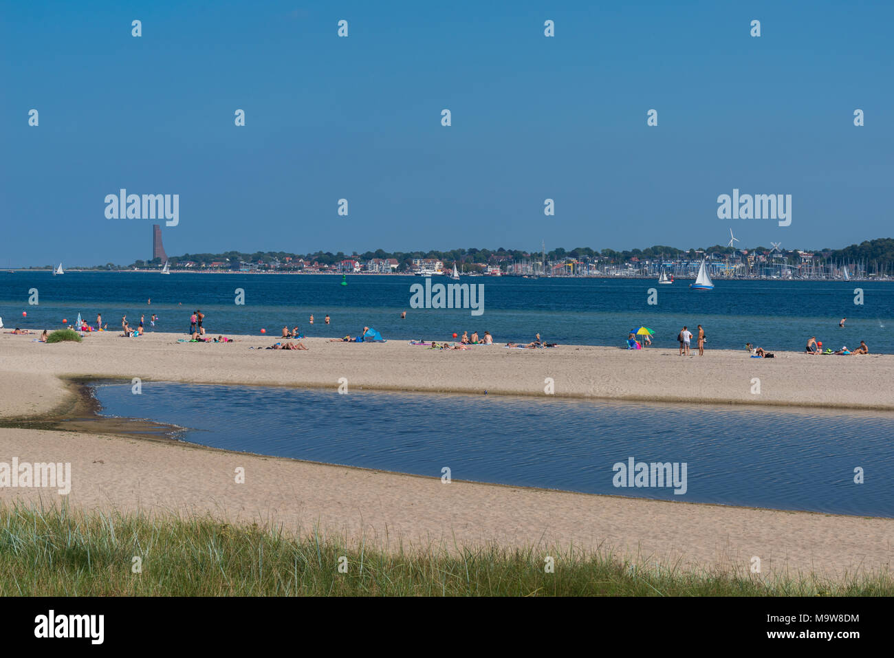 Summertime at the Kiel Fjord. People having fun sunbathing on ...