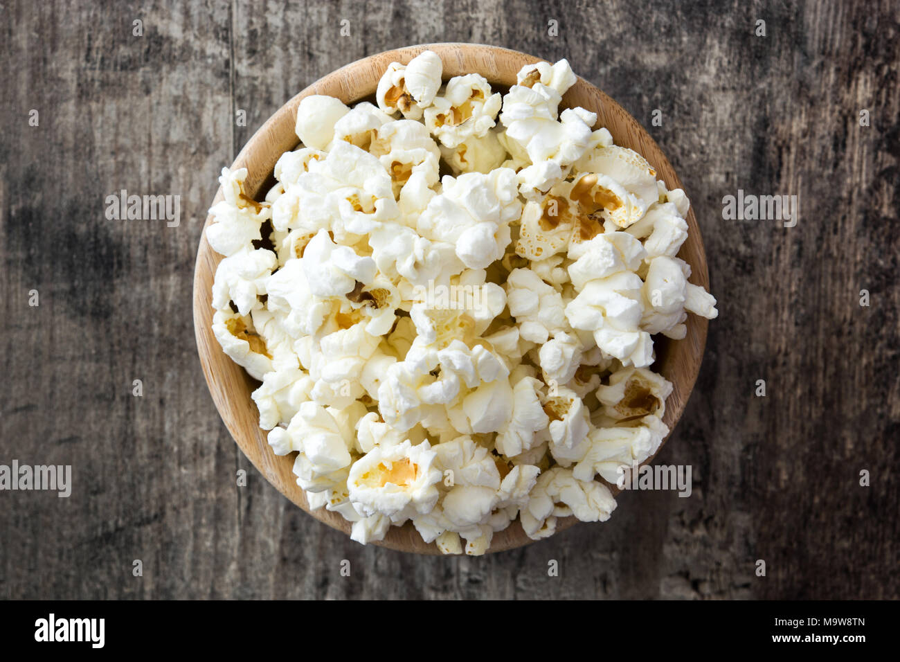 Popcorn in bowl on wooden table Stock Photo - Alamy