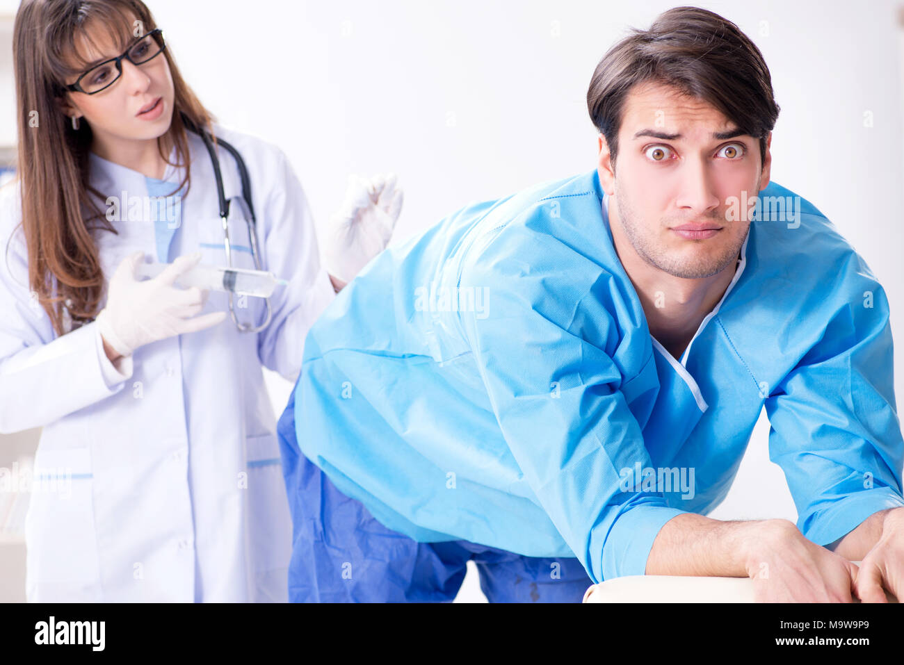 Funny man getting ready for buttocks syringe shot Stock Photo - Alamy