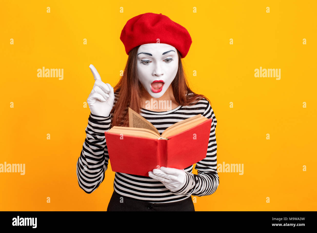 Portrait of cute mime woman read book and finger up. Emotions and ...
