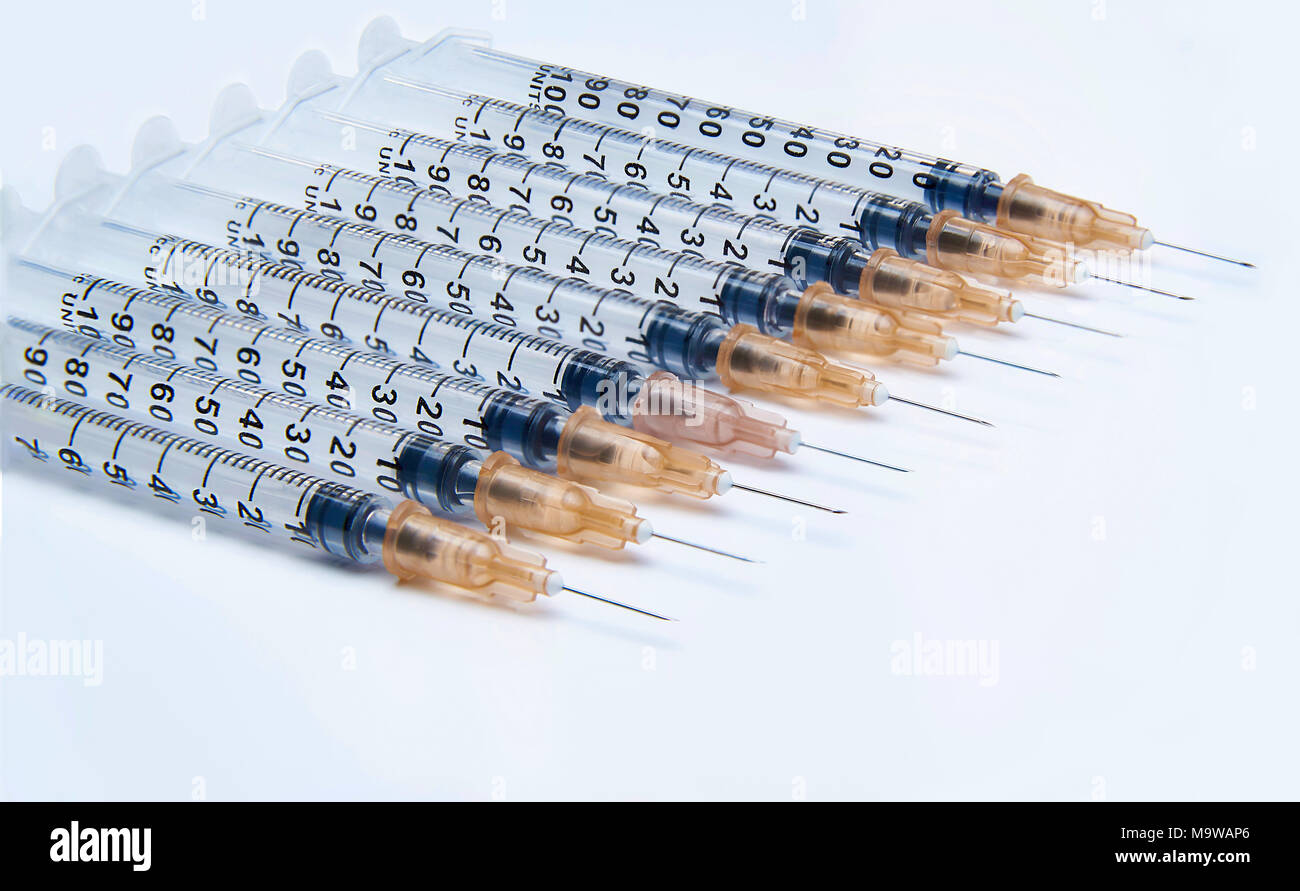A series of insulin syringes with needles close-up isolated on white ...
