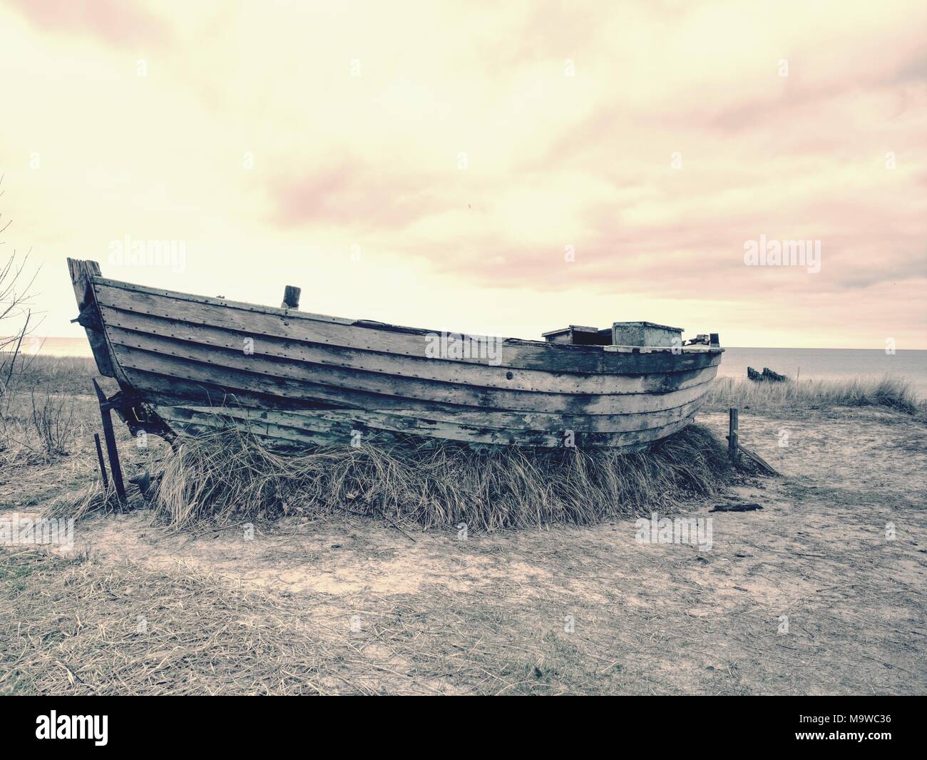 Wrecked fishing boat on old dry grass. Abandoned wooden ship with ...