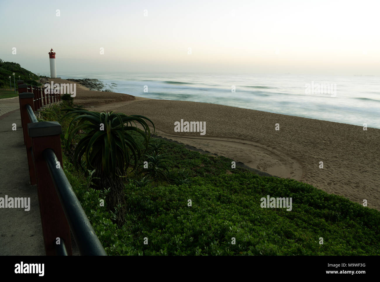 View of boardwalk and lighthouse along beachfront of travel destination ...