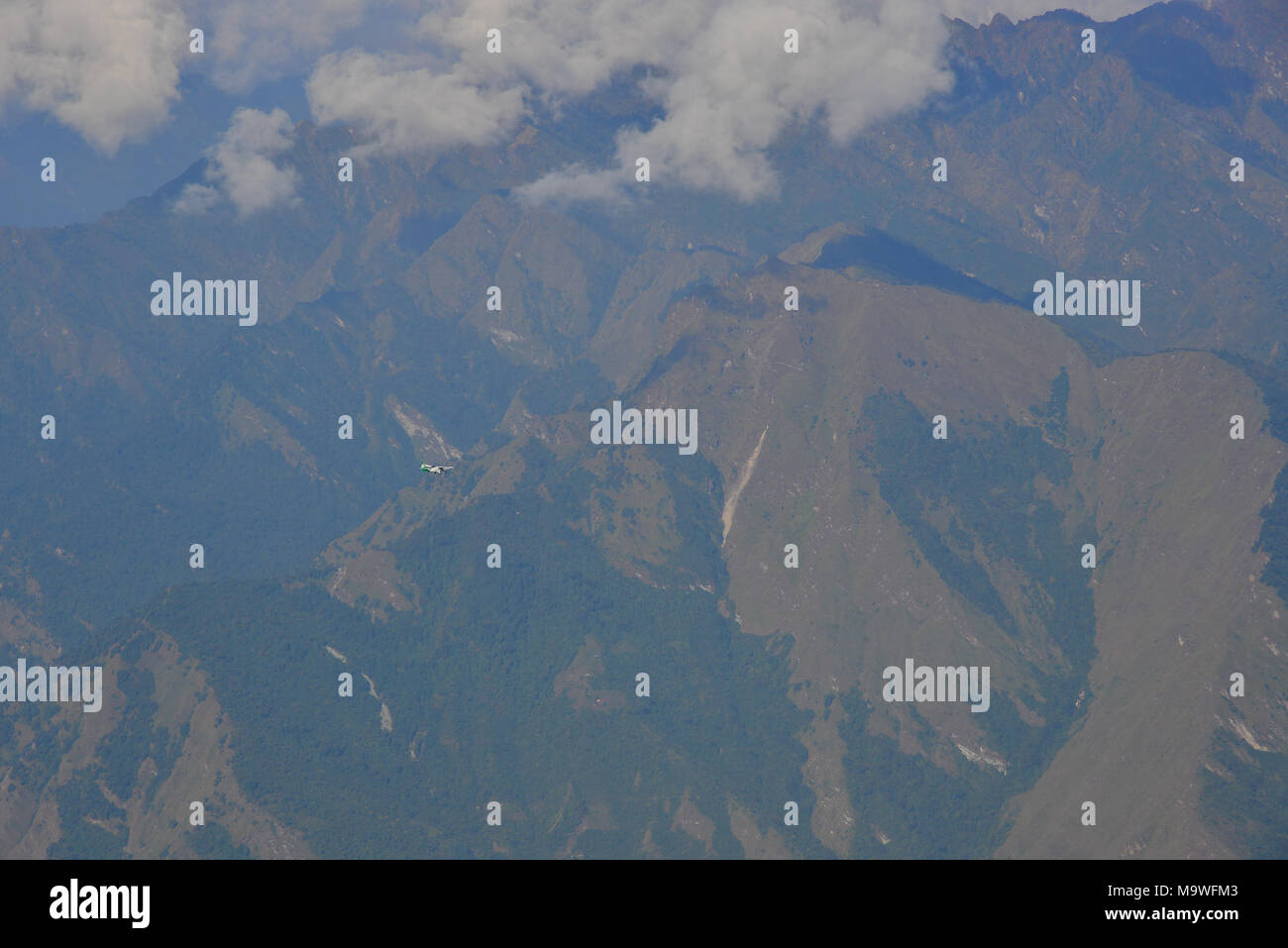 Mountain scenery with an aircraft flying in the sky Stock Photo - Alamy