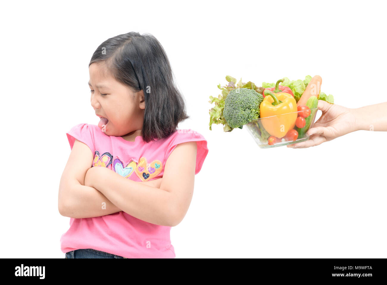 asian child girl with expression of disgust against vegetables isolated ...
