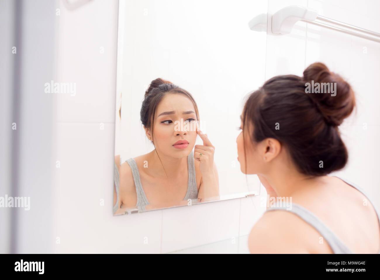 Beautiful woman touching her face by hands in her bathroom Stock Photo ...
