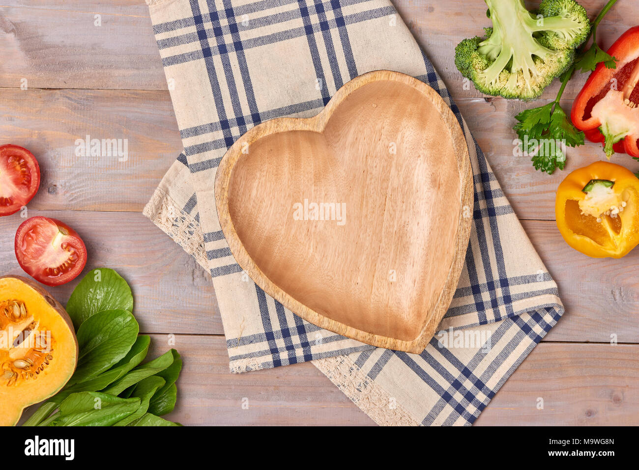 Include fresh organic vegetables and wood heart disk on wooden floor ...