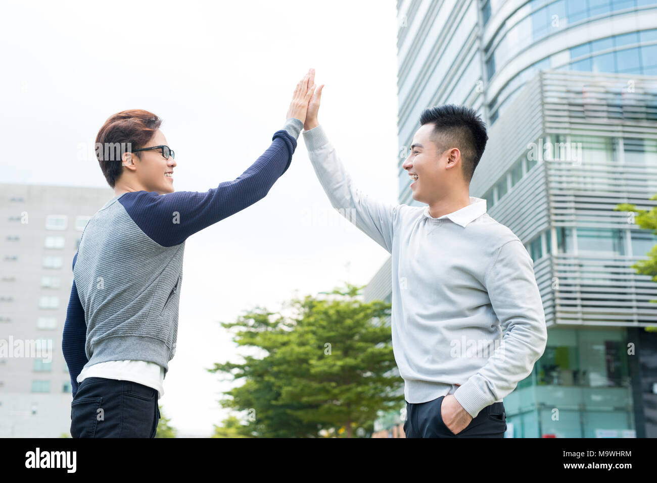 Two businessmen celebrate victory, goal reach, high five Stock Photo ...