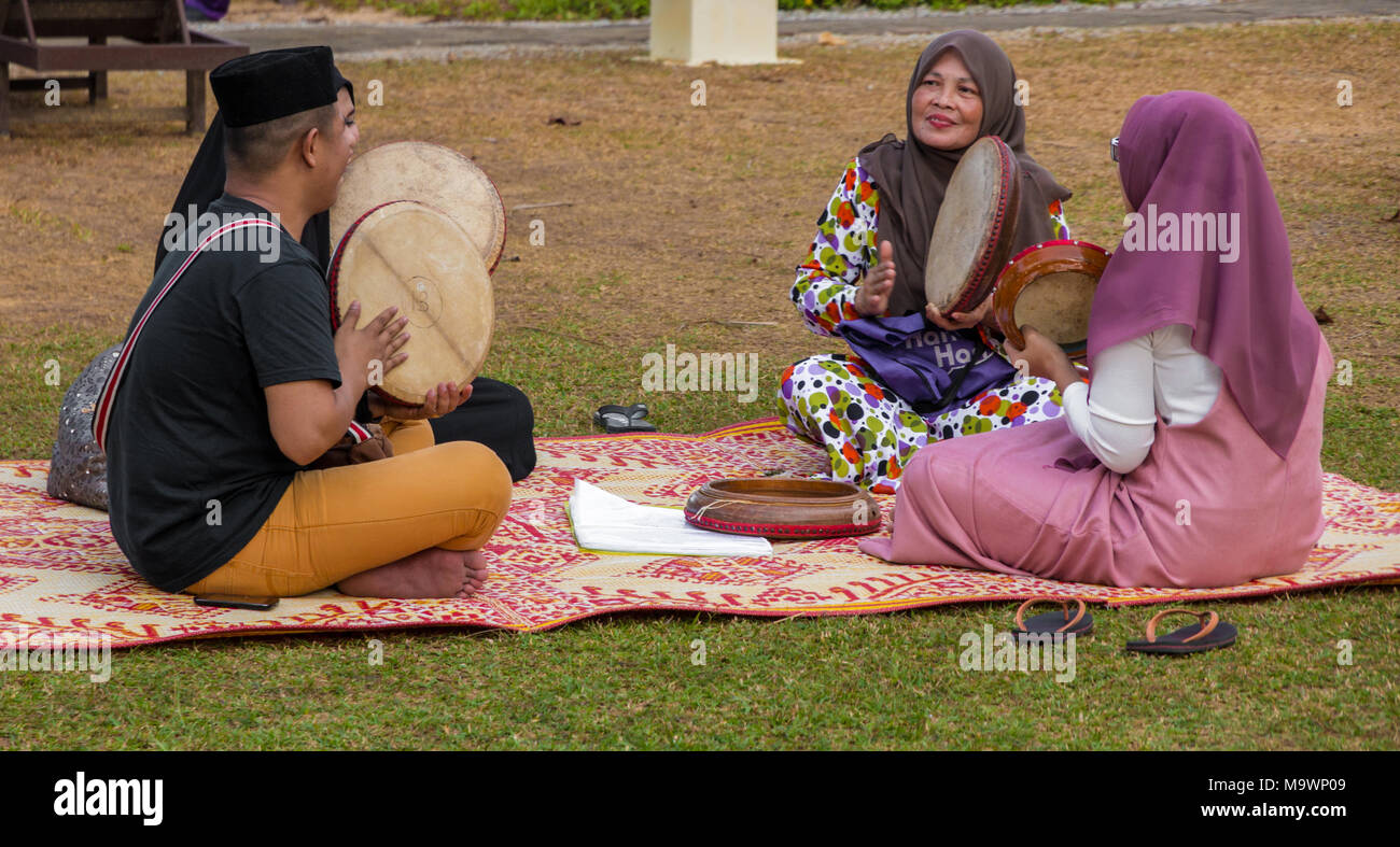 One Malay man wearing a sonkok and three women wearing hijabs are ...