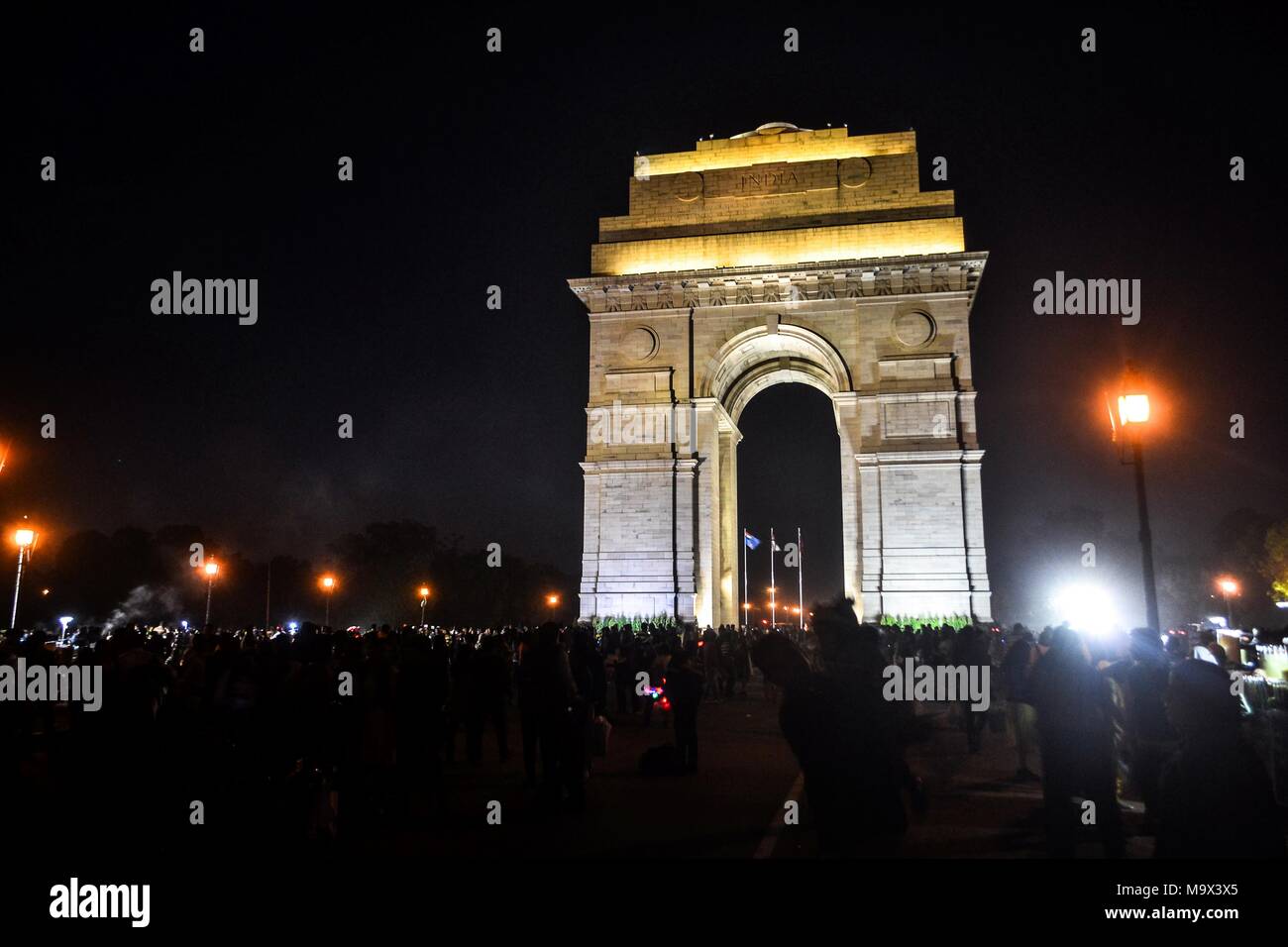 Visitors walk near the India Gate at night in New Delhi, India. India ...