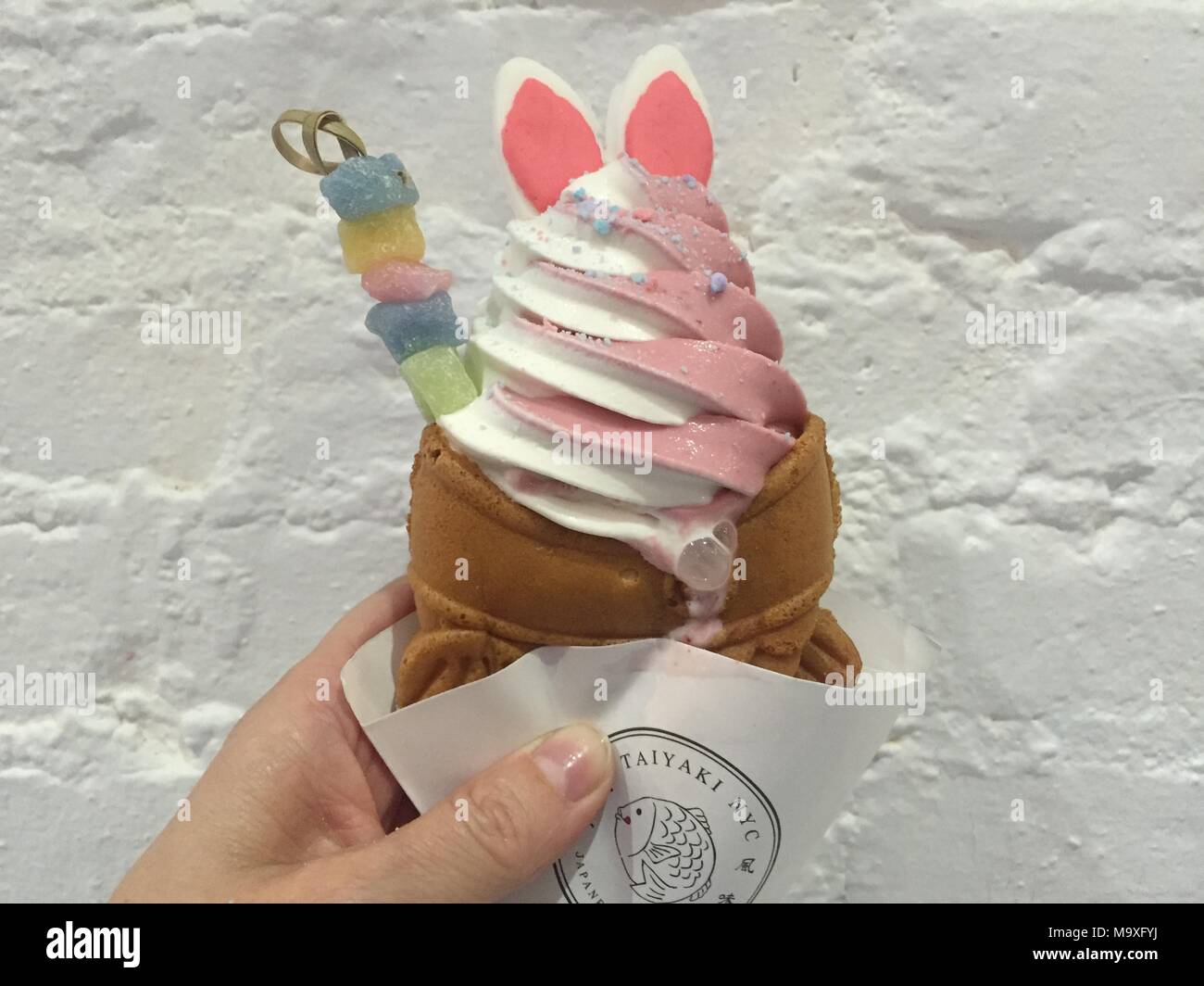 27 March 2018, USA, New York: White rabbit ears decorate an ice cone of ...