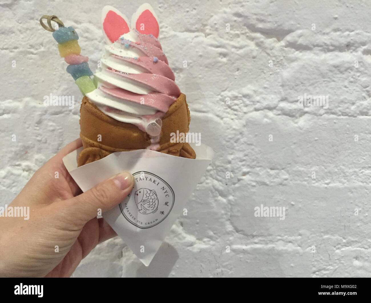 27 March 2018, USA, New York: White rabbit ears decorate an ice cone of ...