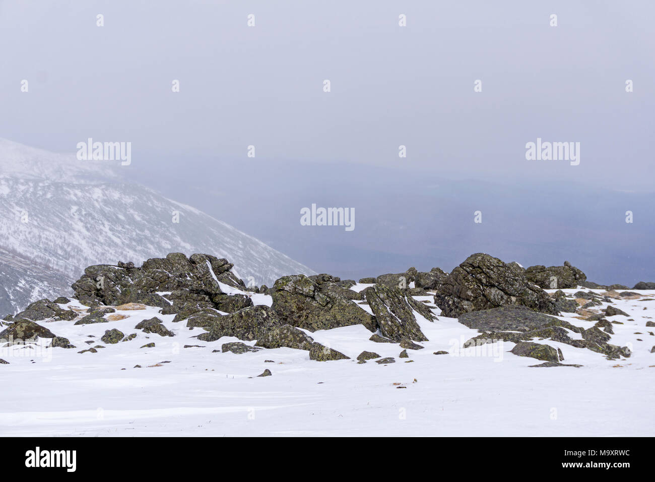Arctic mountain landscape with granite boulders protruding from under ...