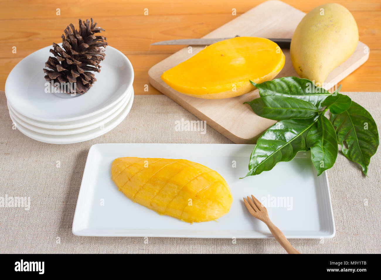 Fresh mango slice on white dish and mangos on wood plate Stock Photo ...