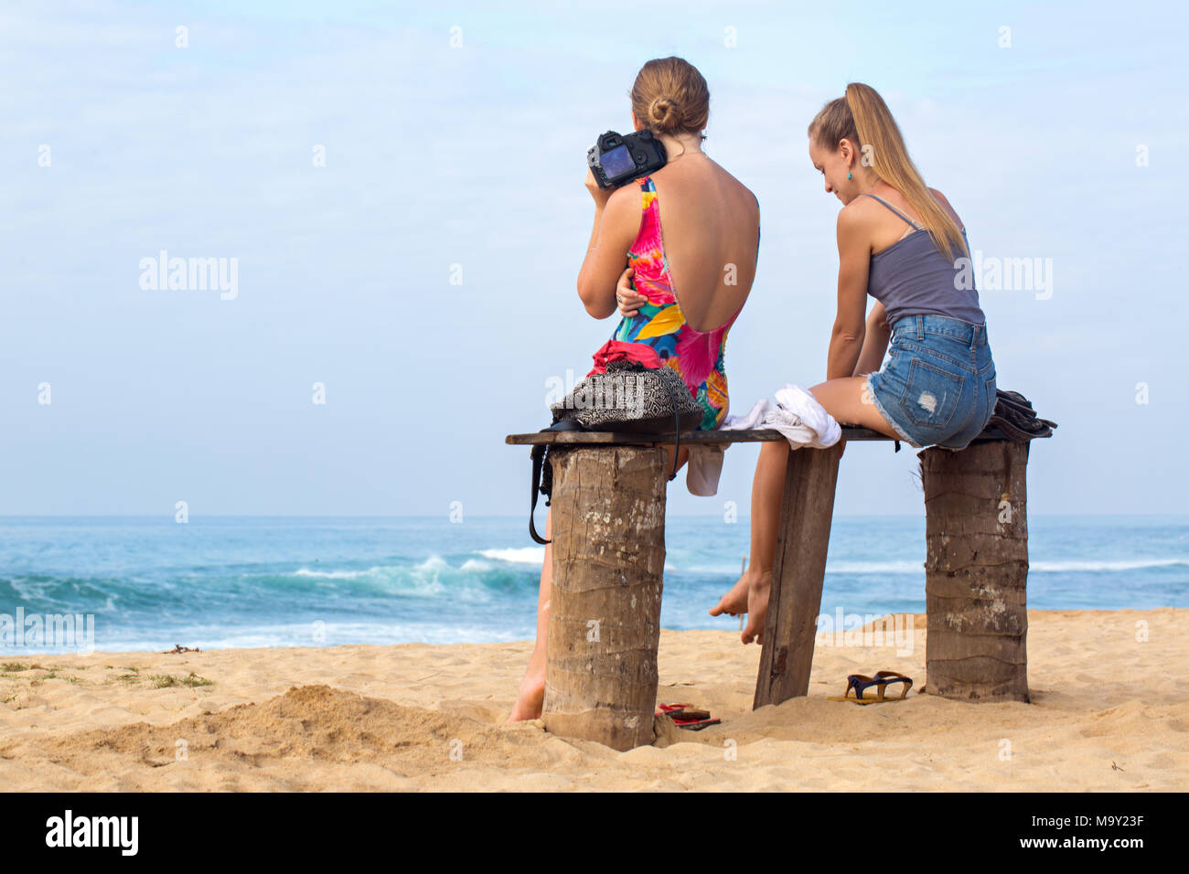 Two young women with camera at the ocean hi-res stock photography and ...