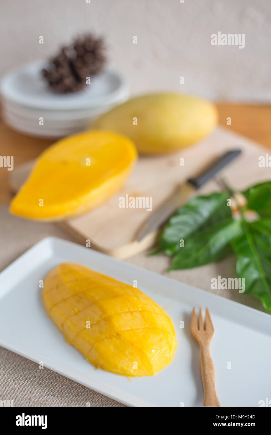 Fresh mango slice on white dish and mangos on wood plate Stock Photo ...