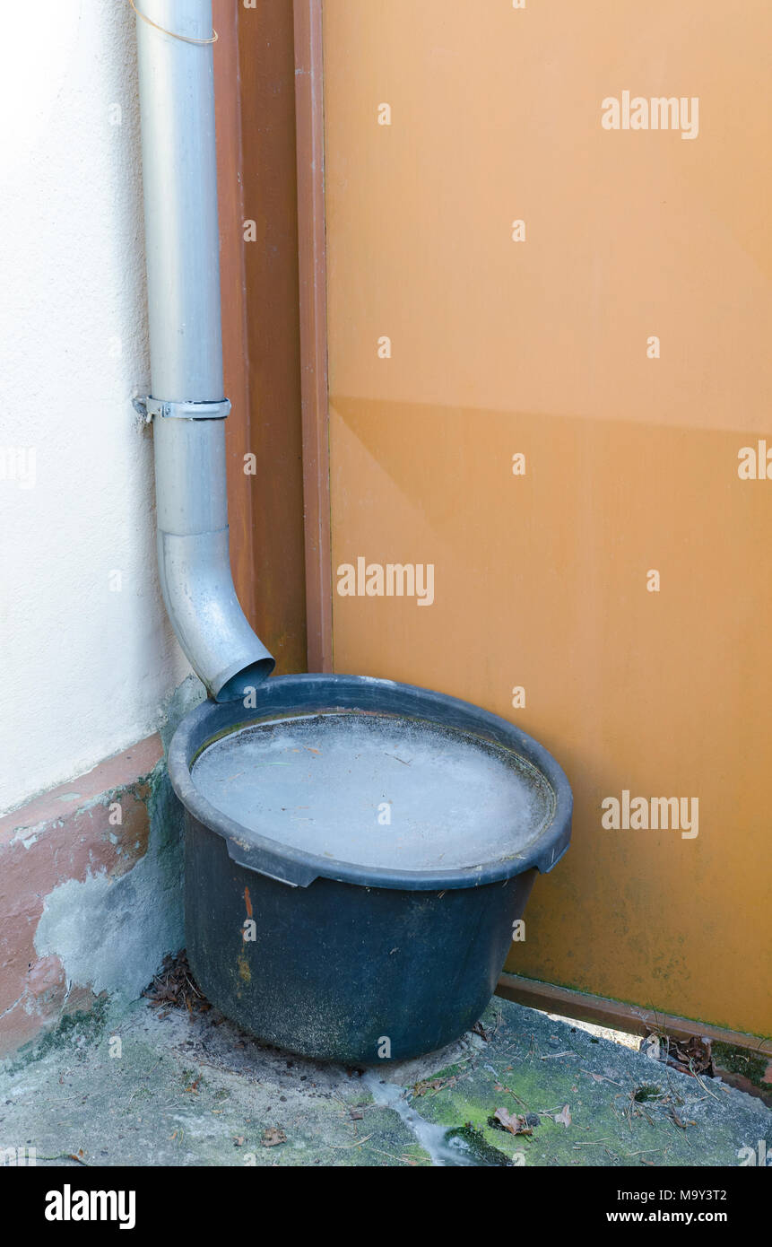 bucket collecting rain water near at a rural house completely frozen in ...