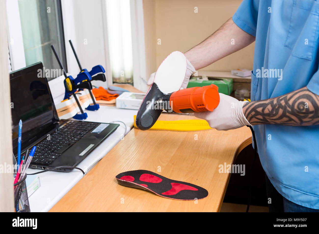 closeup Hands of young man with tattoo in workshop dressed in blue ...