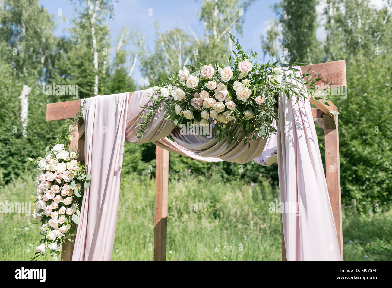 Wooden arch decorated with flowers, are in the zone of the wedding ...