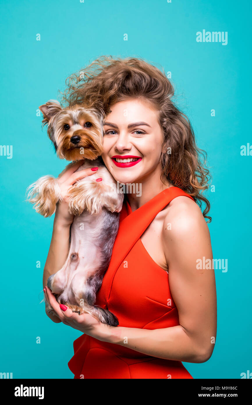 Girl with yorkie dog. Beauty young girl in red dress hug her sweet ...