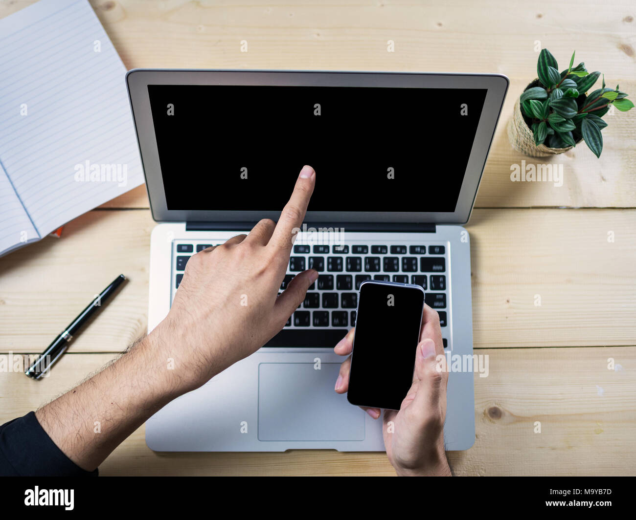 Pointing at computer screen laptop and holding smart phone, flat lay ...