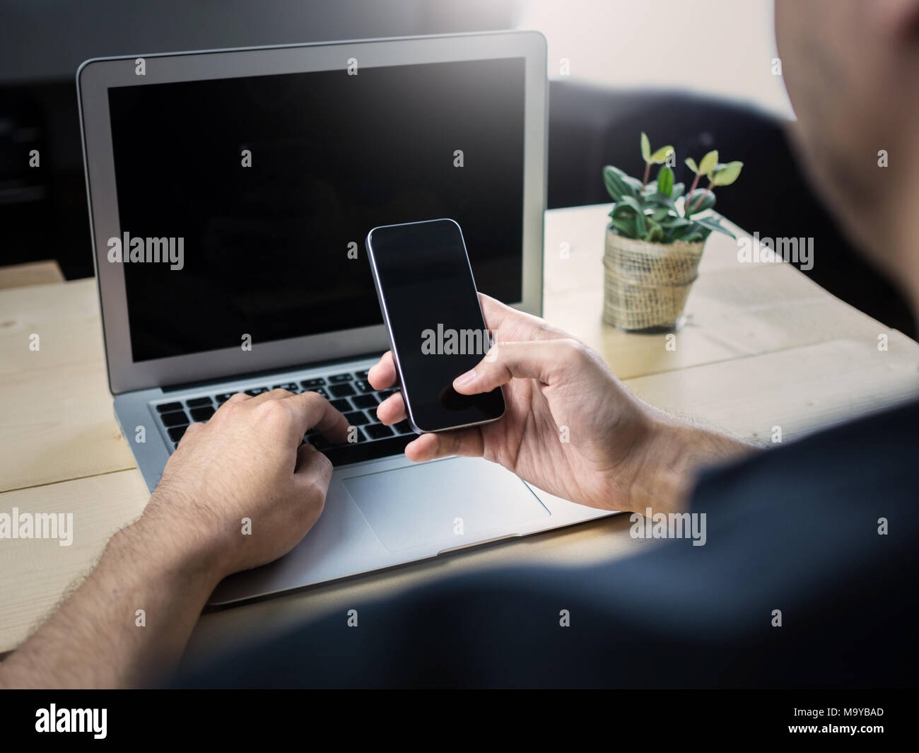 Pointing at computer screen laptop and holding smart phone, flat lay ...