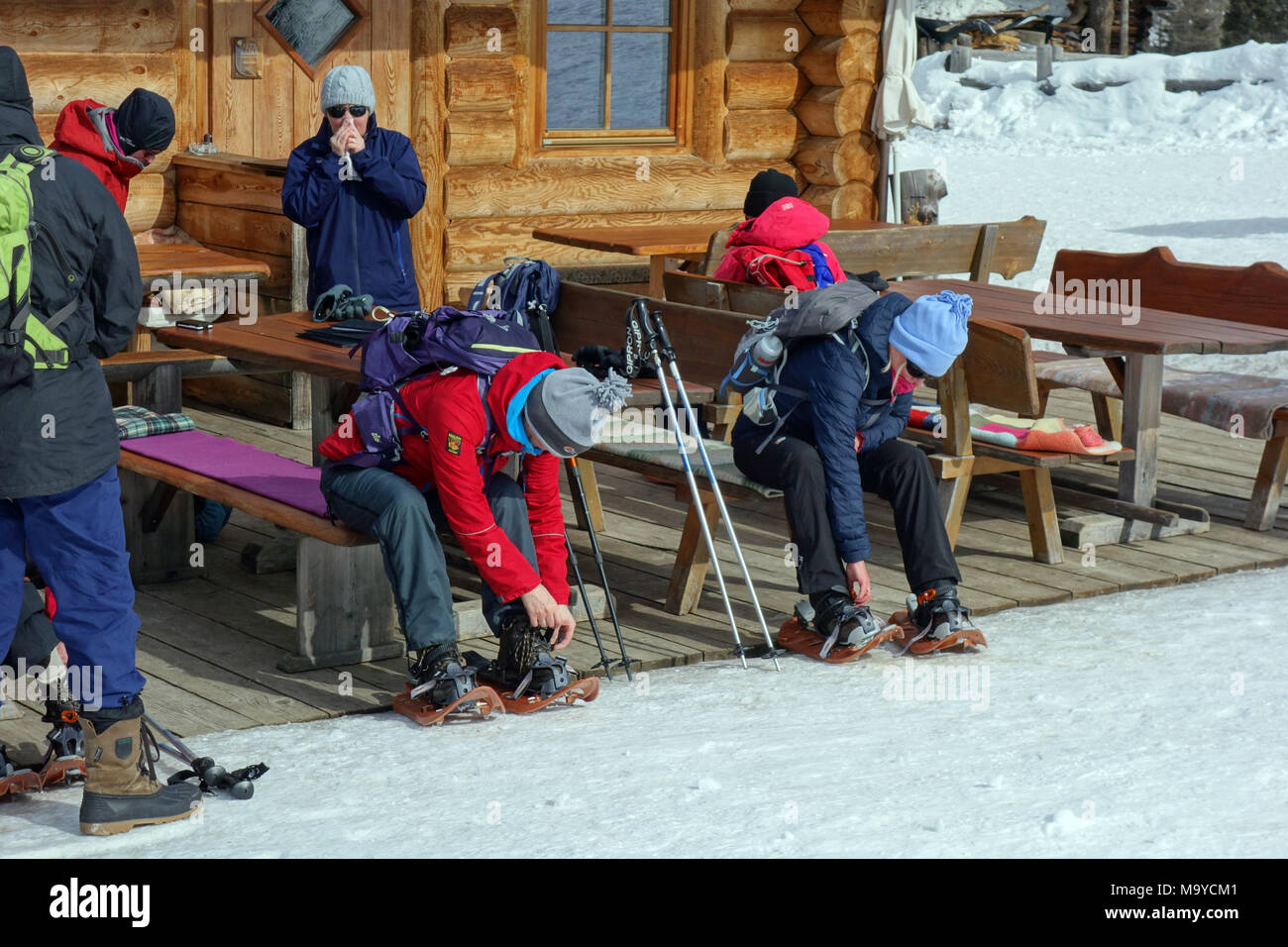 Two Women Putting on Snow Shoes outside Ranch Hutte "Da Andre" Rifugio ...