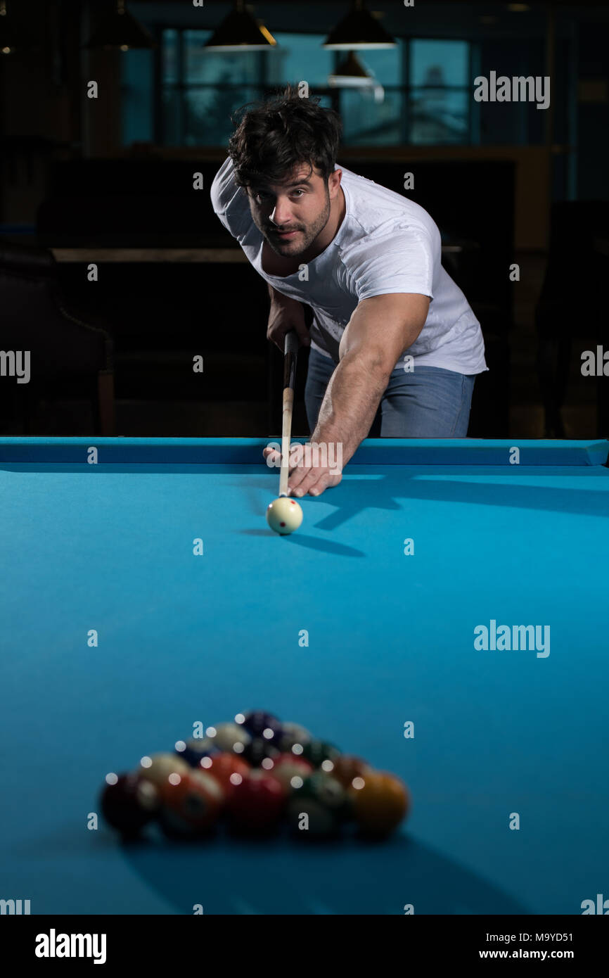 Young Man Lining To Hit Ball On Pool Table Stock Photo - Alamy