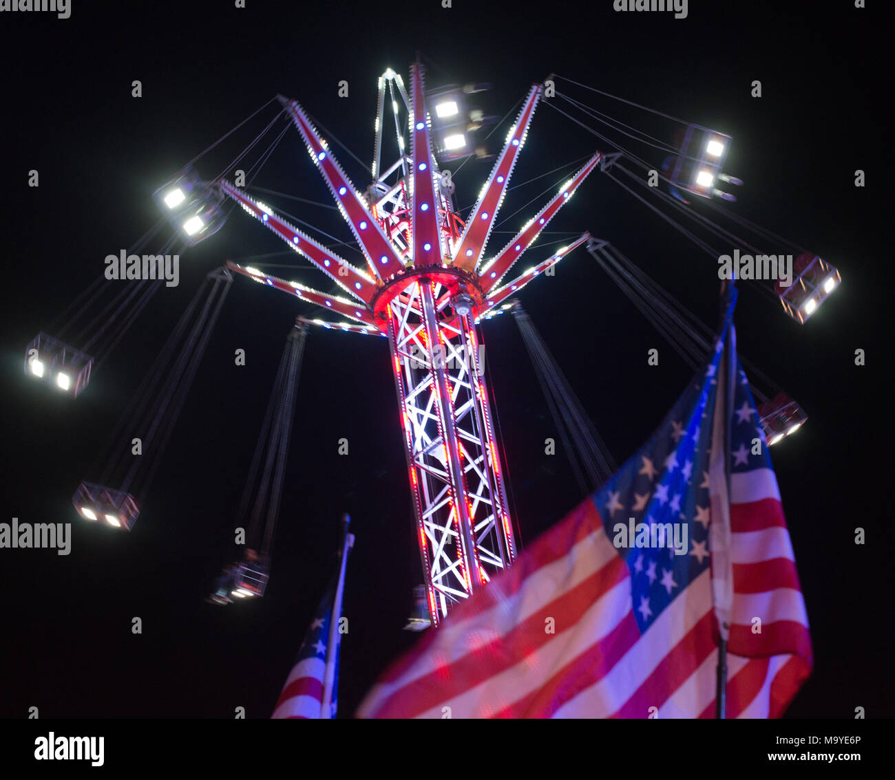 fairground ride with US stars and stripes flag in foreground Stock ...