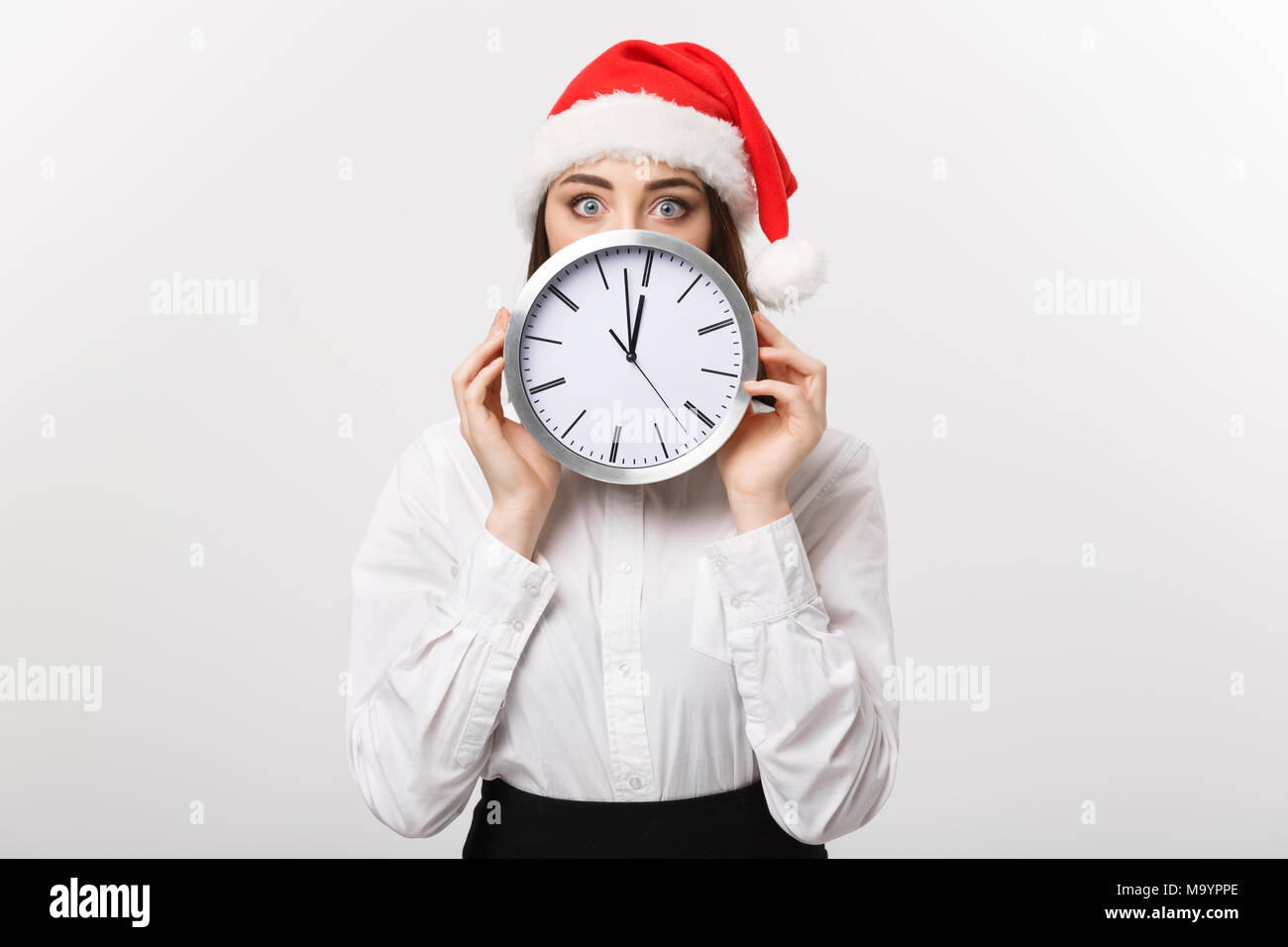 Time management concept - Young business woman with santa hat hiding ...