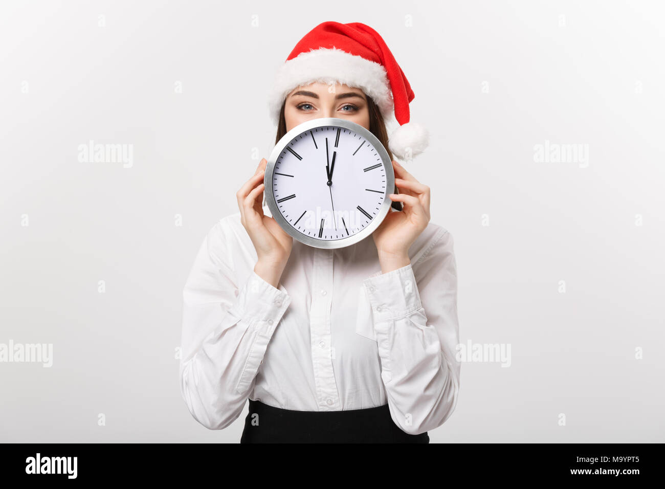 Time management concept - Young business woman with santa hat hiding ...