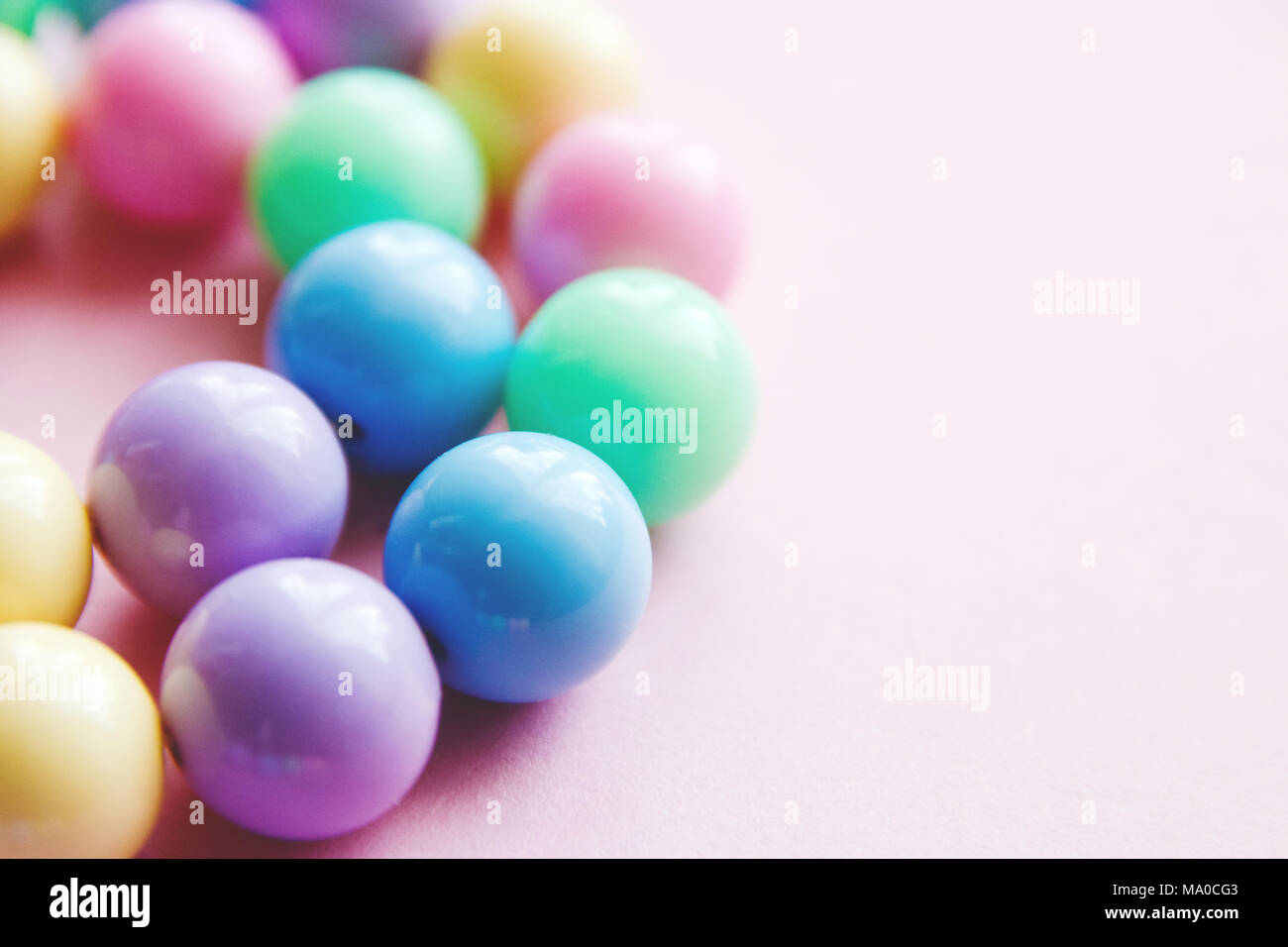 gently spring colored beads on pink background Stock Photo - Alamy