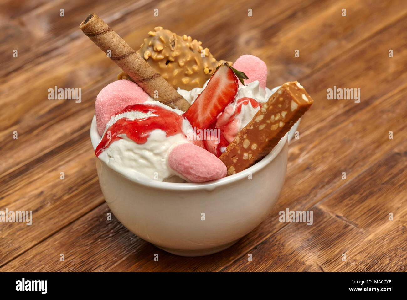 Sundae ice cream cocktail in bowl with wafer and candy on wooden ...