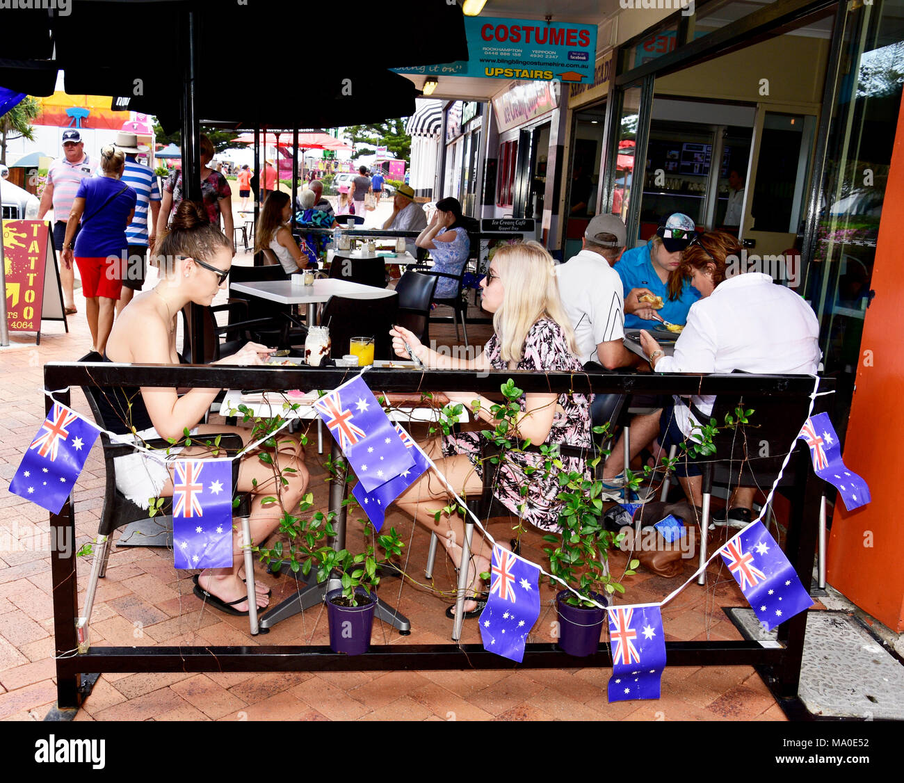 YOUNG WOMEN ENJOYING AN AUSTRALIA DAY BREAKFAST IN A SIDE WALK CAFE ...