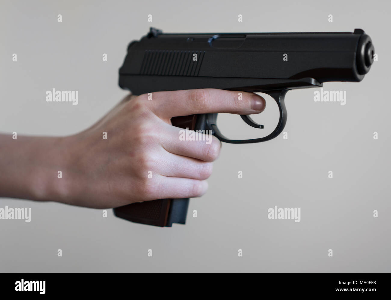 Child hand holding a gun and aiming Stock Photo - Alamy