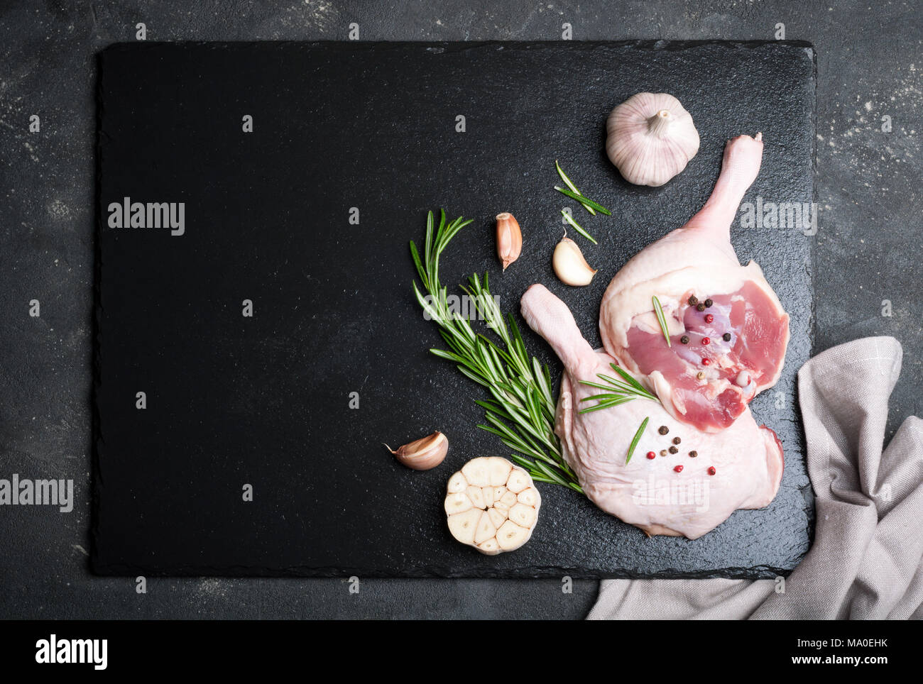 Raw meat, duck legs on cutting board with rosemary and spices, top view ...
