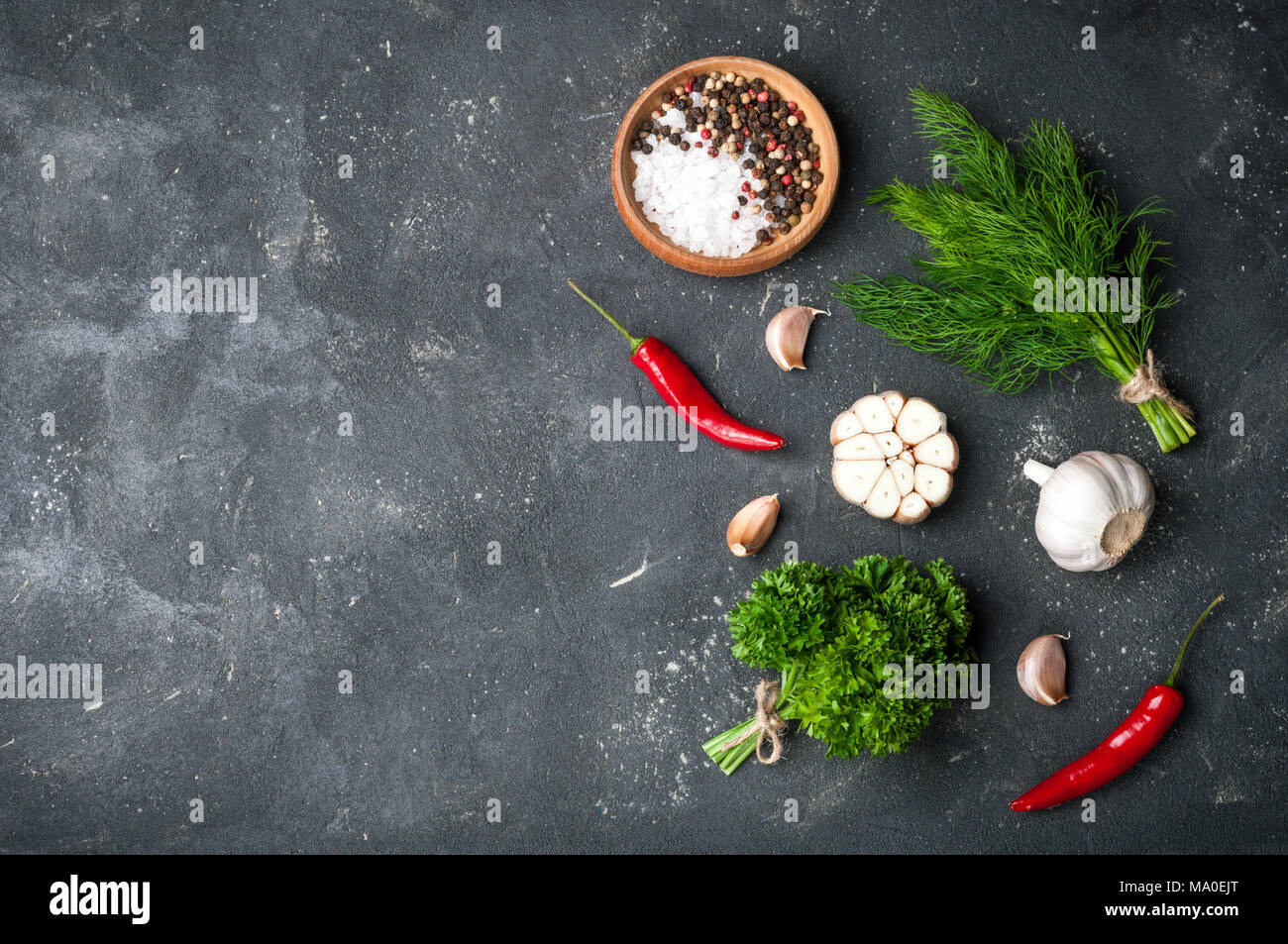 Herbs and spices cooking on stone table. Parsley, dill, garlic and ...