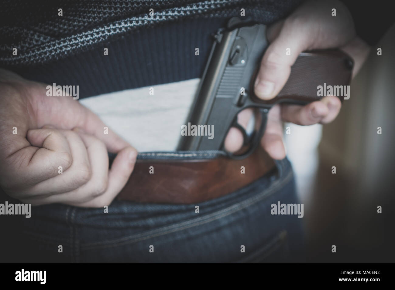 Man hiding gun behind his back Stock Photo - Alamy
