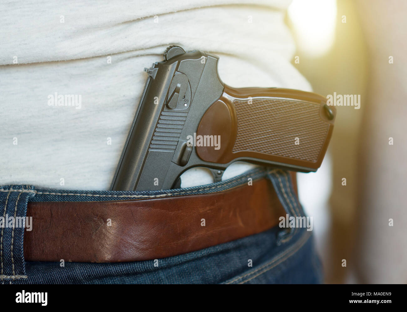 Man wearing gun behind his back Stock Photo - Alamy
