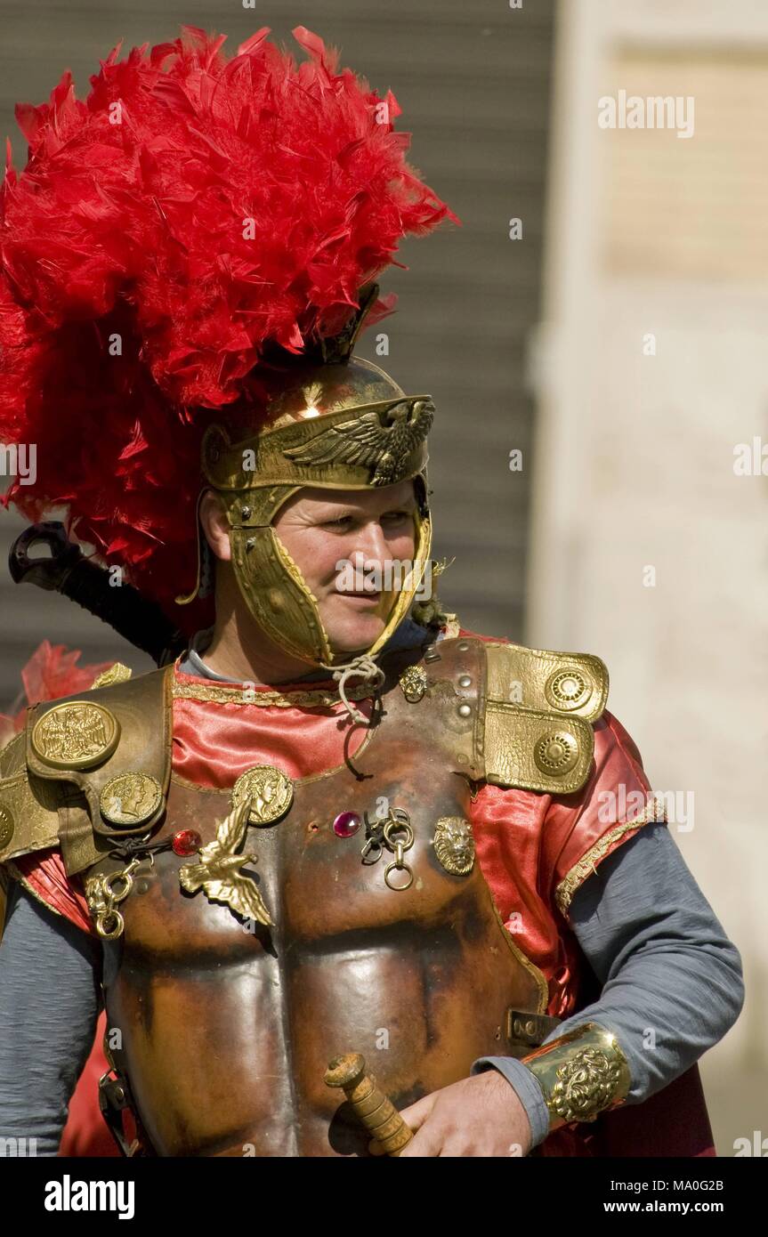 Man dressed as a Roman soldier, next to a military banner, outside the ...