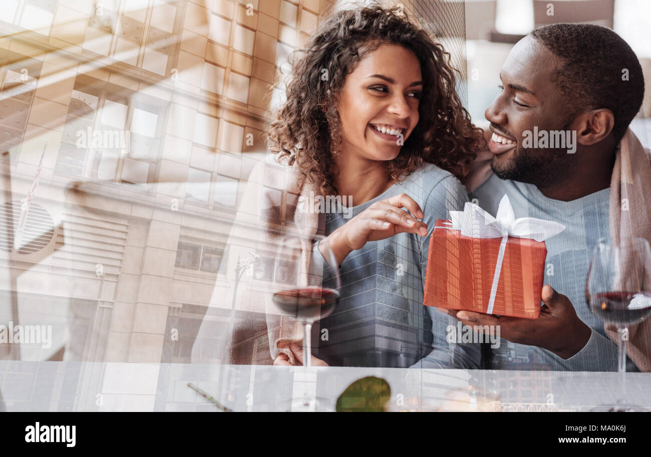 Adorable couple holding a present in hands Stock Photo - Alamy