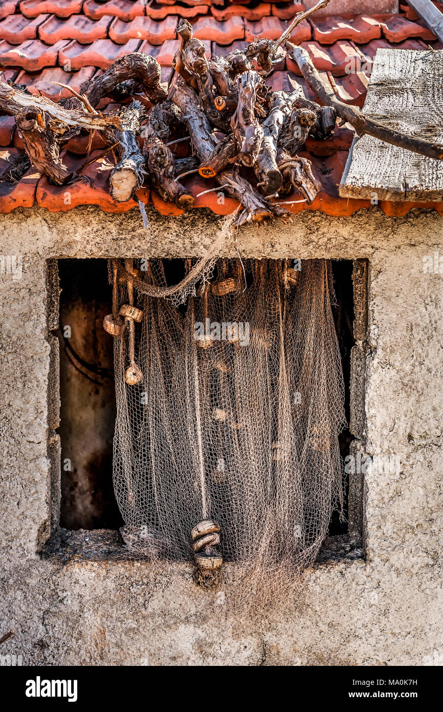 Fishing net hanging in window of hut in the fishing port of Sali on ...