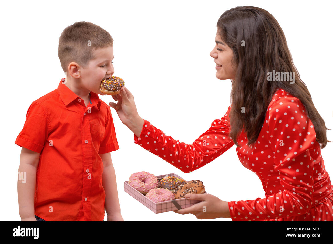 Baby boy toddler eat sweet donut. a woman is feeding a baby with a ...