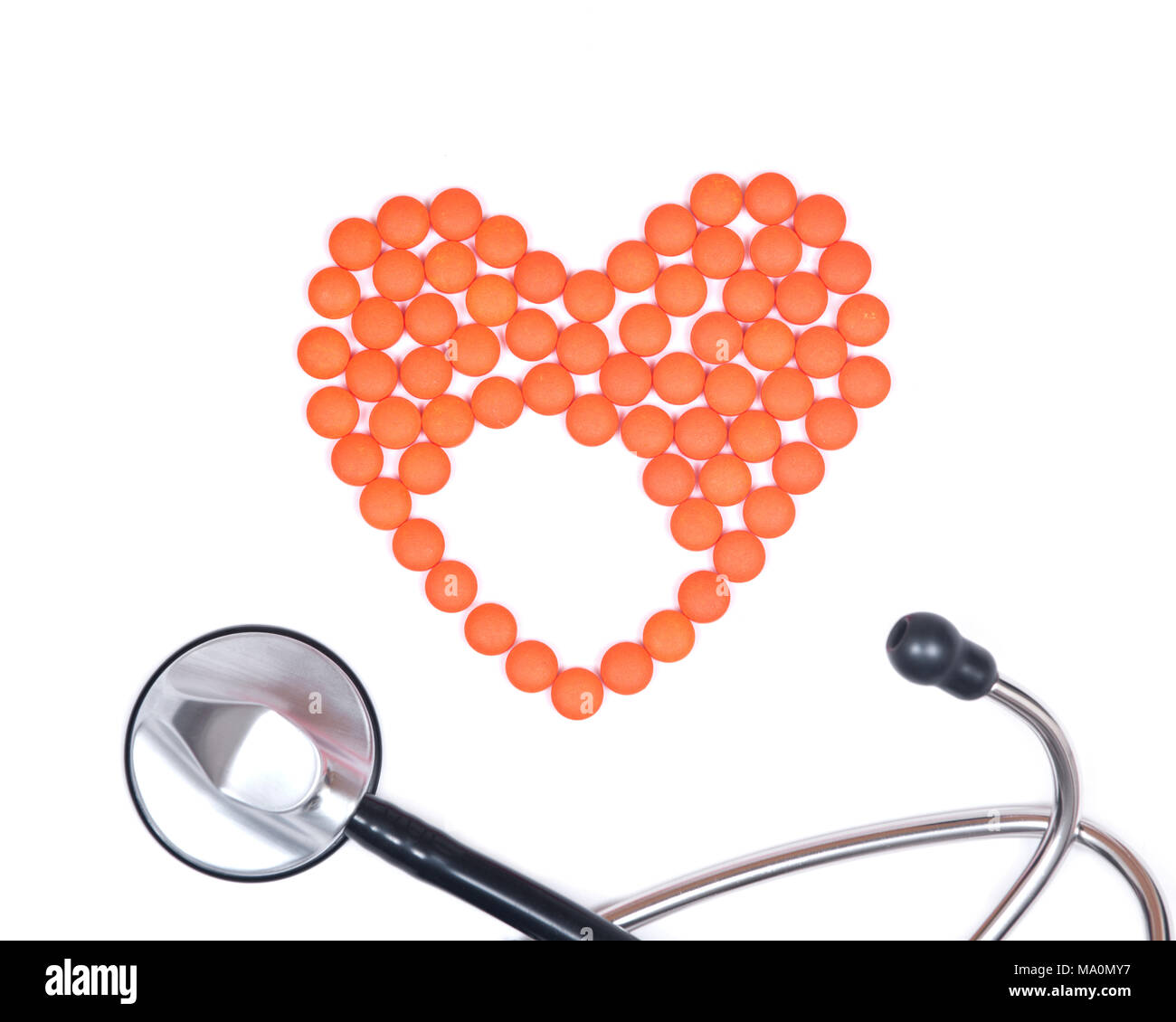 Heart shape orange pills and black cardiac professional stethoscope ...