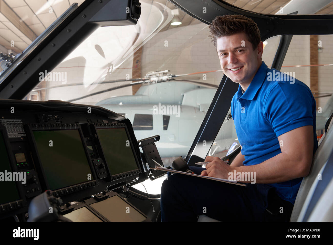 Portrait Of Male Aero Engineer With Clipboard Working In Helicopter ...